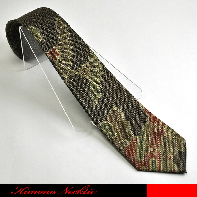 商品説明正絹の越後紬吉沢織物のラベルがついています。ソフトな感触でです。菊の花のデザインです。一見すると茶系等のふんわりとした色あいですが、緑、赤の糸も入った織りになっています。落ち着きのなる民芸調のネクタイです。素材は新古の着物反物から縫...