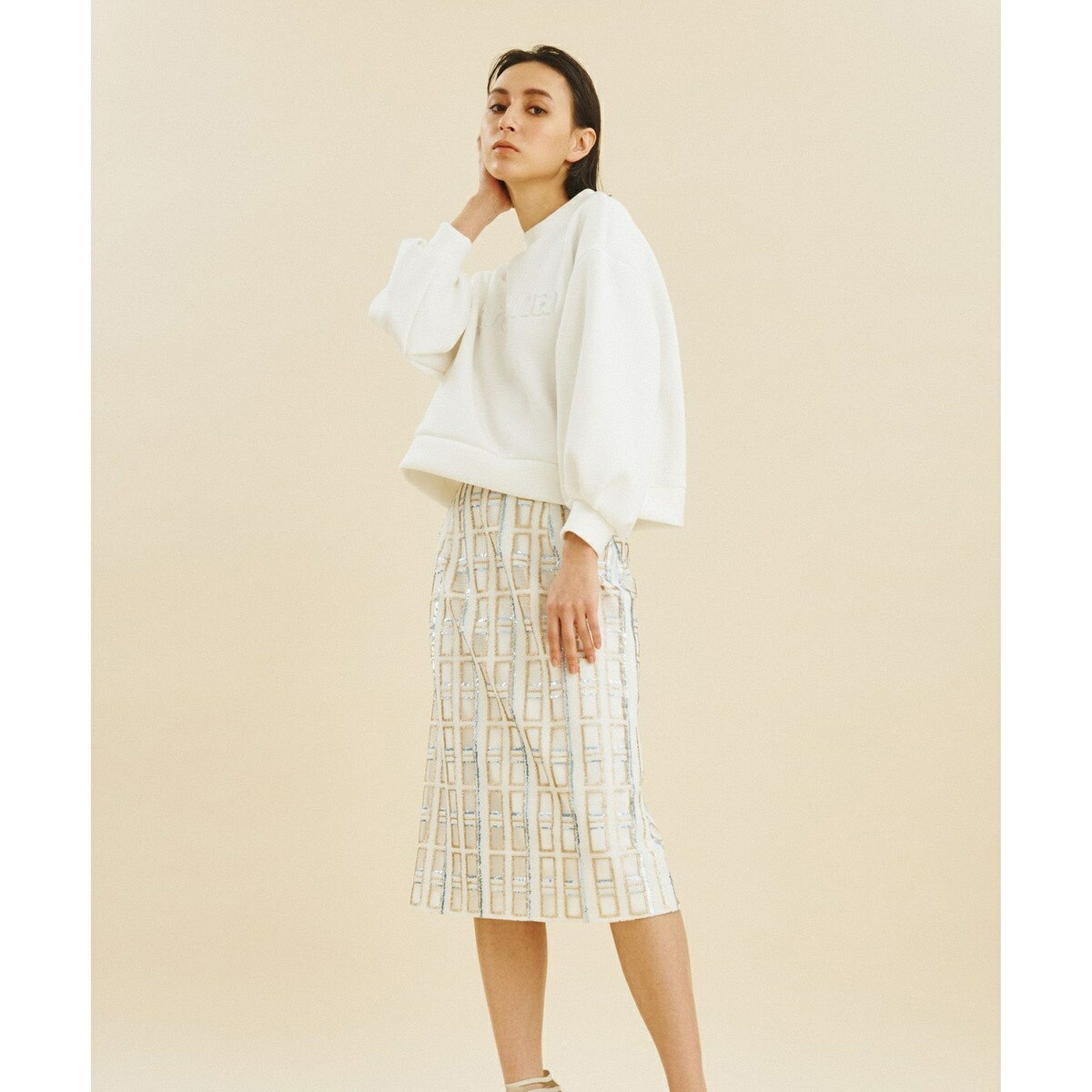 [型番：0223121038]オリジナル図案のチェック柄をスパンコールで表現した、煌びやかな刺繍スカート。手作業で縫い代の刺繍を外し、丁寧に美しく縫い上げた特別感のある一枚です。すっきり見えするタイト型ですが、足のラインを拾わない絶妙なシル...