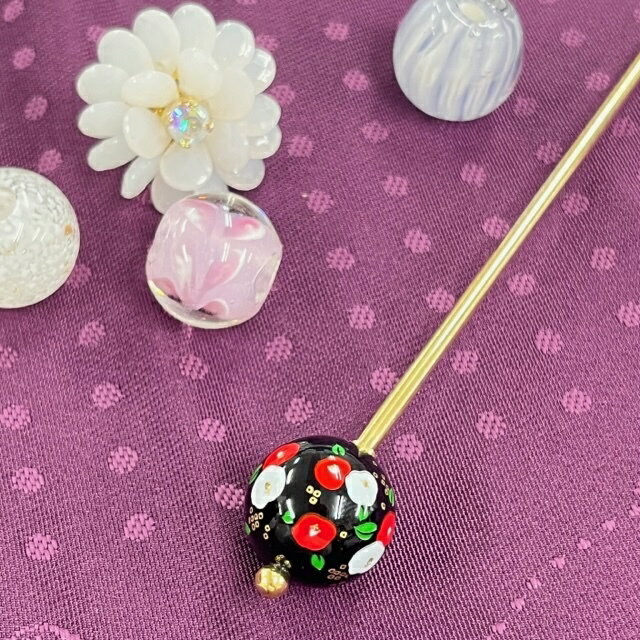 [型番:co-2573]黒ベースに白、赤色の椿が映える玉かんざし。シンプルかつ華やかなデザインとなっております。※こちらの商品は2023年12月1日から価格改定を実施させていただきます。お届けする商品についているタグが旧価格の場合がございま...