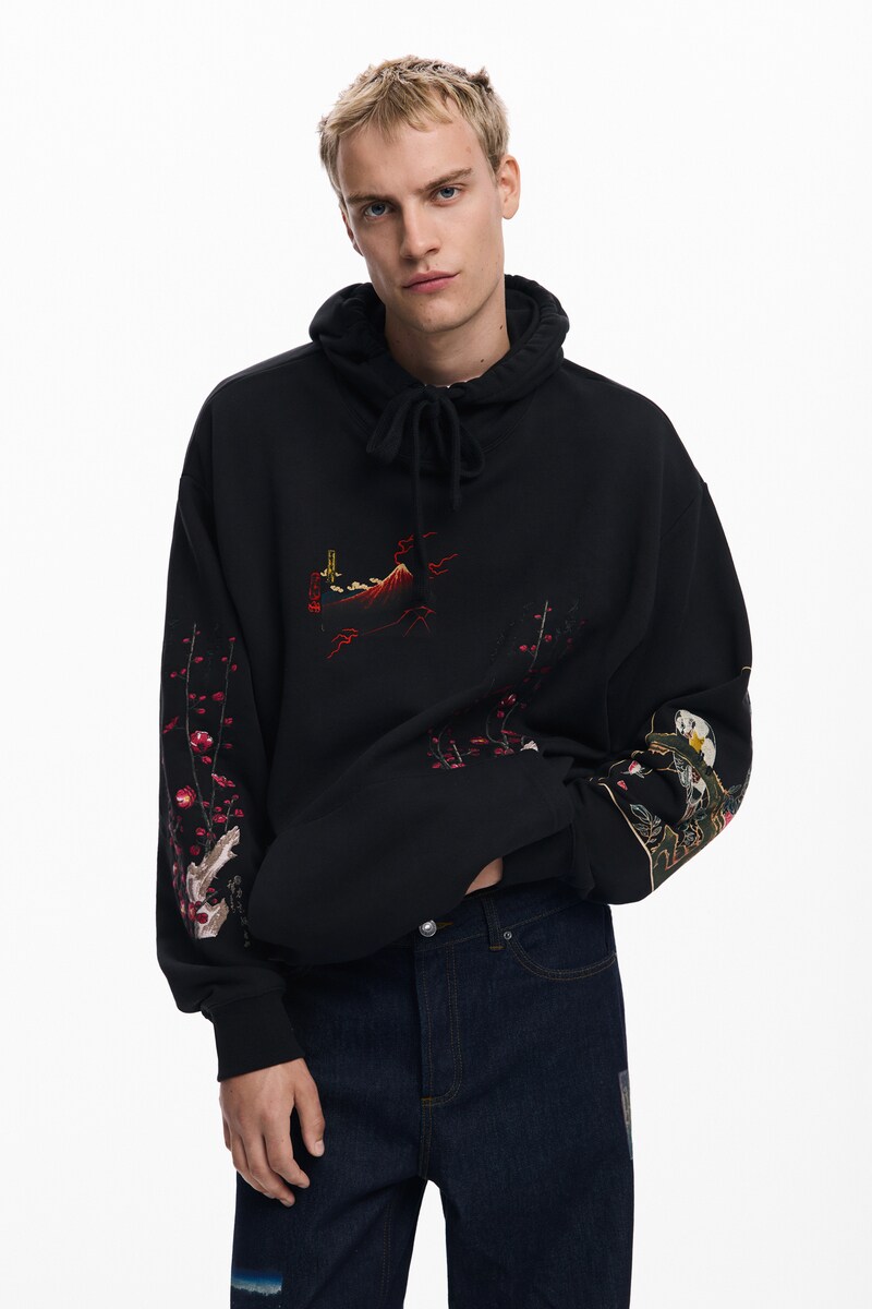 [型番:25WMSK13]風景や東洋風のテキストのさまざまな画像がプリントされた、長袖のフード付きスウェットシャツ。【Desigualデシグアル】バルセロナ発のファッションブランド「Desigual（デシグアル）」。スペイン語で“他とは違う...