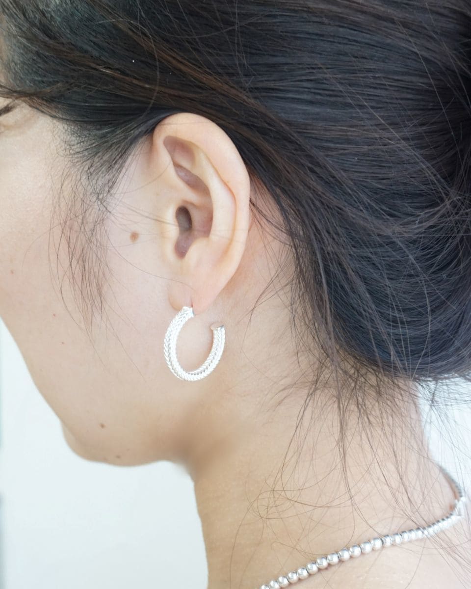 [型番:1014183025]シルバーの輝きが編み込まれたようなブレードモチーフのフープピアス。デイリー使いから、フォーマルなシーンまで幅広く使用できます。同デザインの少し小さめサイズ（直径20mm）もご用意しています。専用ポーチ付き○シル...