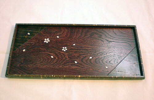 やや小さめのトレー。木目を見せながら桜皮を部分的に使い、あっさりとしたデザインに仕上げました。来客時のおもてなしとして、又、ティータイムのおともに！！お使いください。 ■社名：八柳 ■規格：15.5×33.7cm