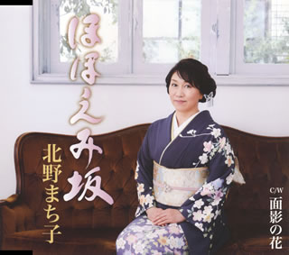青森県弘前市出身のベテラン演歌歌手、北野まち子の約1年ぶりとなるシングル。石原信一が作詞を手がけた「ほほえみ坂」は、哀切のなかにも温かさと希望がみえる。「面影の花」は自身が歌謡曲の世界に初めて挑戦したナンバーだ。【品番】　KICM-3100...