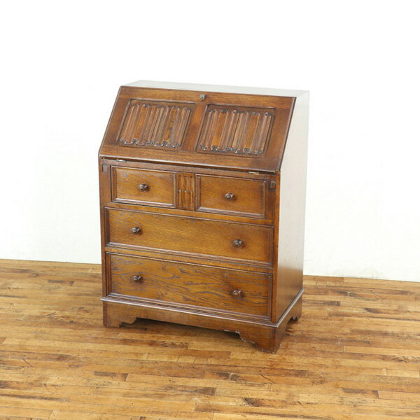 品番 80404 品名 ライティングビューロー 原産国 イギリス 材質 オーク材 年代 1940年頃 サイズ 横幅：78cm　奥行：43cm(拡張時74.5cm)　高さ：99.5cm(デスク高70cm) 商品について 扉のリネンフォールドの...