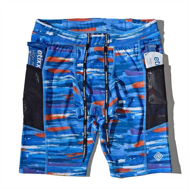 Joshua Middle Spats(Blue) E2406325 数年前からいち早く男性ランナー向けの総柄ランニングタイツを提案し、世のランナーへ新たなスタイルとして浸透させた、ブランドオリジナルのテキスタイルを用いた総柄のハーフタイツ...