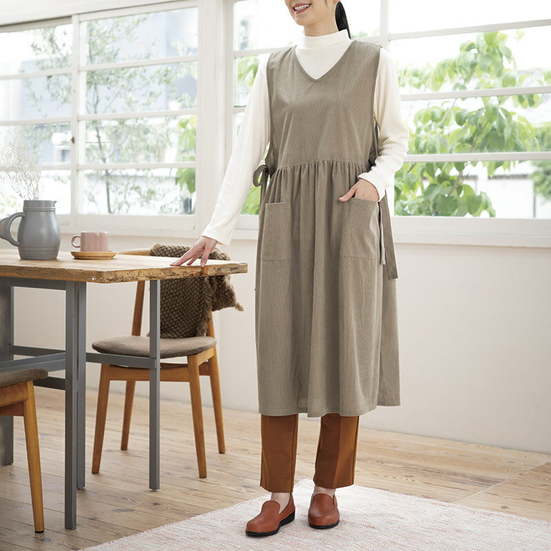 サイドリボンのおしゃれロングエプロン 顔周りがすっきり見えるVネック仕立て 柔らかな細コール天素材の、 裾が揺らぐワンピースのようなデザインは 着るだけで楽しく過ごせます ◆素材 ポリエステル100％ ◆サイズ M〜L バスト：106 身丈...