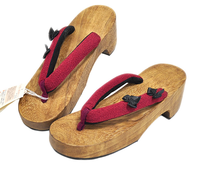 焼き桐のモダンな形状の台に、縮緬の鼻緒をすげた女物右近下駄です。 鼻緒に付けられたリボンがポイントです。 モダンでスタイリッシュな浴衣によく合います。 踵も若干高くなっており個性的なフォルムを持っています。 鼻緒自体も柔らかく太目に仕立てて...