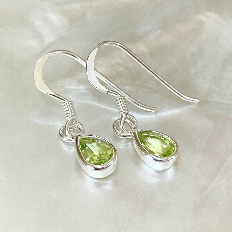 しずく型のペリドットが美しいフックピアス。 透明度の高いグリーンカラーのペリドットが美しくカッティングされています。 揺れると光に反射してキラキラと輝きとてもきれい！ ◆フック上部からの長さ：22mm ◆モチーフの大きさ：5mm×10mm　...