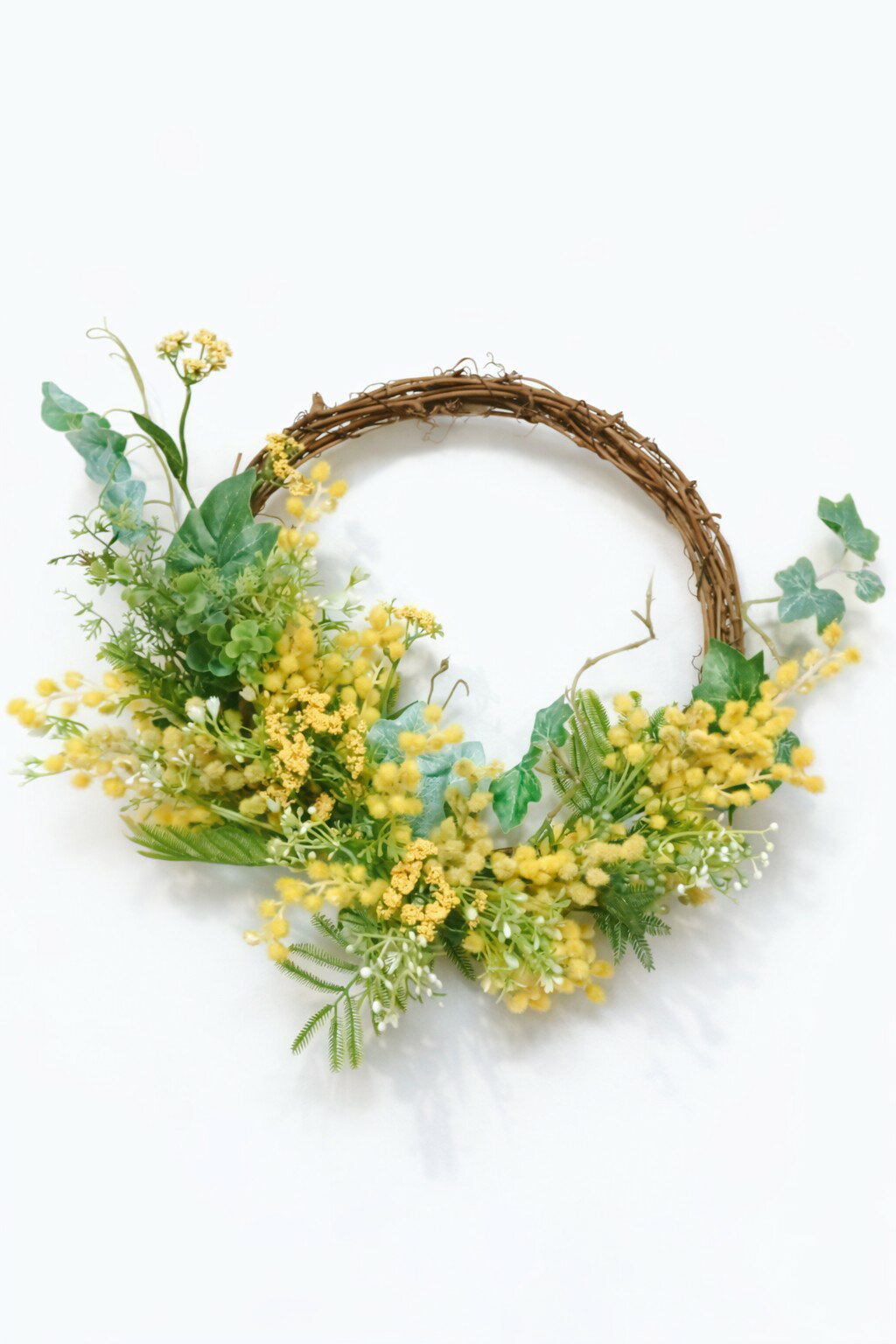 （ハンドメイドフラワーリース） 自然の息吹を感じる、ナチュラルで華やかなフラワーリース。 繊細に編み込まれたツイッグベースに、やさしいイエローの花々ミモザと瑞々しいグリーンをふんだんにあしらいました。まるで春の森を切り取ったかのような、爽や...
