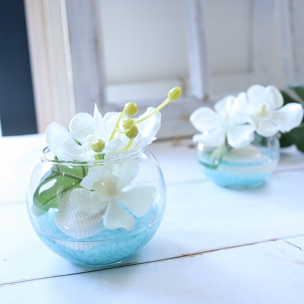 商品情報使用花材使用花材・・・　モカラ　モンステラ　貝殻　カラーサンド　アーティフィシャルフラワー使用。サイズ高さ・・・ガラス花器底面からトップの花(グリーン)まで　　　約10-11センチ前後ガラス花器　　　　　9φ　x　8H注意点・本製品...