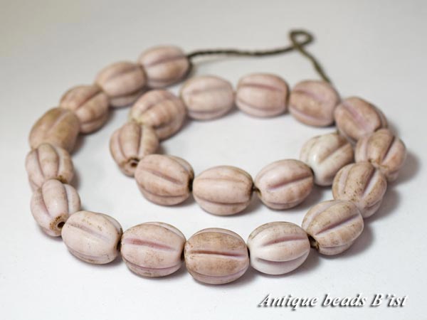薄い紫色卵型の母胎に筋が施されたガラスビーズ一連です。パキスタン等では、このビーズを連にして壺等を装飾するそうです。ネックレスのTOPにすると可愛いと思いますよ〜！やや汚れがありますが、状態は概ね良好です。粒のサイズ、孔の大きさに若干のばら...