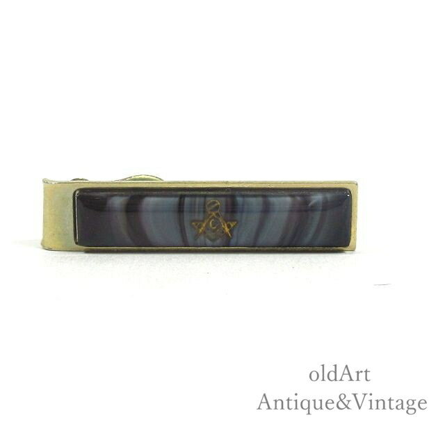 こちらは、アメリカ製ビンテージ1950年代頃のフリーメイソンオフィシャルのタイピンになります。 フリーメイソンのコンパスと直定規のシンボルマークが刻まれており神秘的な雰囲気です。 フリーメイソンにおいて個々の建築道具は人間の美徳と対応し、コ...