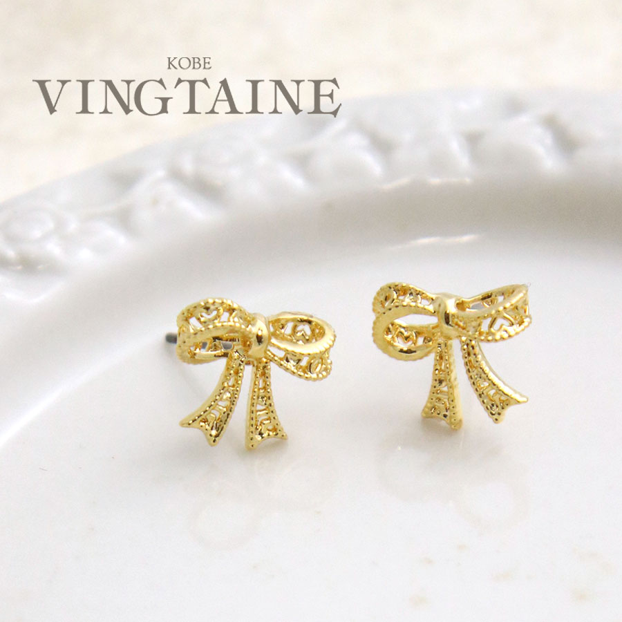 商品説明繊細なレースの様なすかし模様とリボンのシルエットが思わずキュンとなる可愛さ。小さなリボンのピアスは清楚な印象で、女性らしさを格段に引き出してくれます。さりげない大きさで、ちらりと見えた時もとびきりキュートです。 サイズ全長：約1cm...