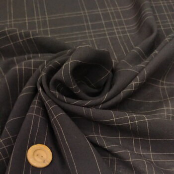 商品名：ビスコース・ウール 平織り生地 チェック柄 ブラック 素　材：ビスコース 62% ウール 38% 生地幅：145cm カラー：ブラック 透け感のあるウール混の生地です。黒地にベージュ系の糸で、やや大きめのチェック柄がある生地です。伸...