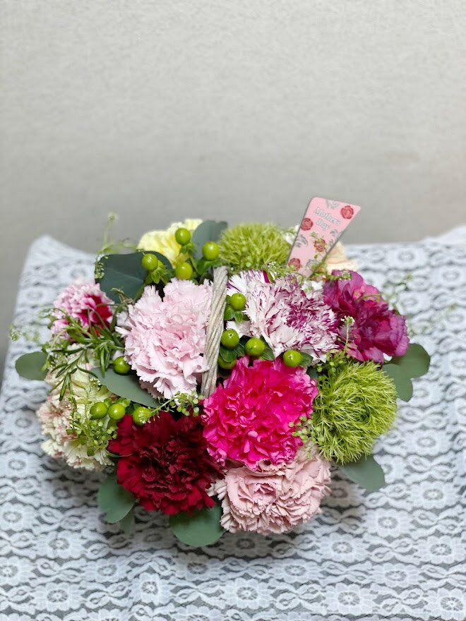 商品説明 サイズ 横30cm、幅23cm、高さ23cm 商品説明 色とりどりのカーネーションとグリーンのテマリ草を、合計12本使用したバスケットアレンジ。人気のユーカリ、ヒペリカム、レピディウムなどを脇役に。母の日用タグをお付けします。花の...