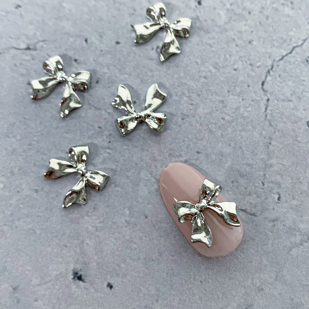 シルバー 立体のかわいいリボンパーツです。 リボンの型が繊細で、ひとつでしっかり存在感があります。 ※一つ一つ手作業の為、商品により若干の個体差がある場合がございます。予めご了承ください。 内容量：15P サイズ：約11mm×11mm