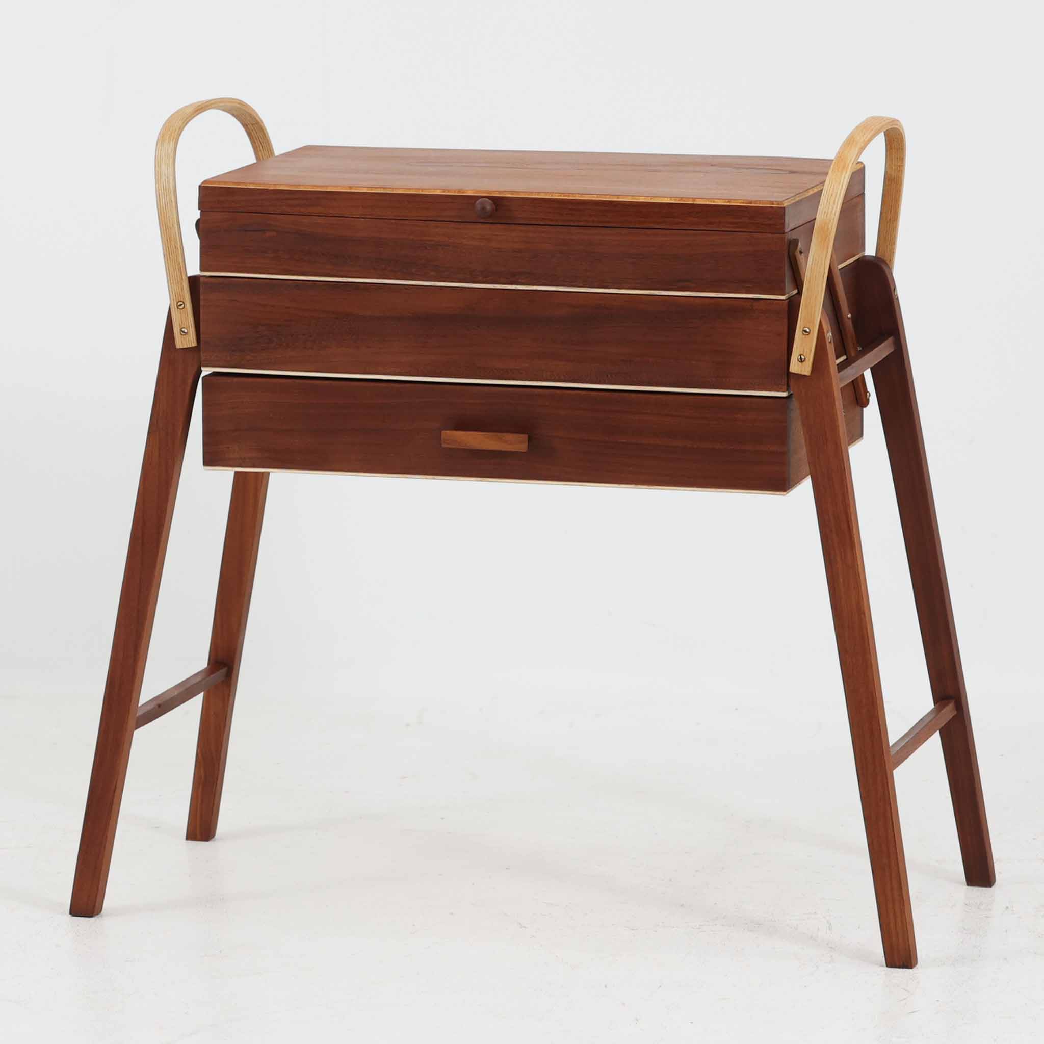 こちらのソーイングボックスは、チーク材とビーチ材を組み合わせた軽やかな構成が魅力の北欧ビンテージ品で、トップのフラップを開くと段違いに展開するトレイと下段の引き出しが現れる優れた収納構造を備え、裁縫道具や小物を効率よく整理できます。柔らかく...