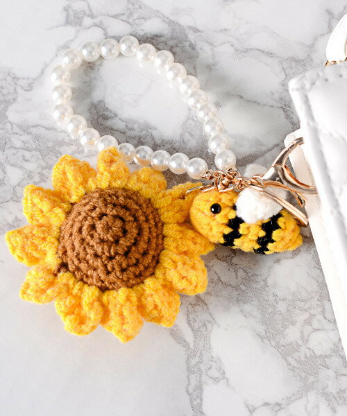 アイテム説明 かぎ針編みで作られたニット素材のキーチャーム。 向日葵と蜂とパールが組み合わさり可愛らしく暖かみのあるデザインです。 バッグに付けるだけでワンランク上のお洒落が楽しめます。 キーホルダーやキーリングとしてもお使いいただけます。...