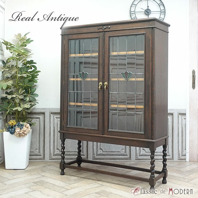 品名・品番 antique58216　ブックケース　1920年頃　オーク材　イギリス サイズ W 110 x D 39 x H 157 cm 商品について ステンドグラスが印象的なブックケースです。 扉部分のふち飾りやツイストレッグの支柱が...