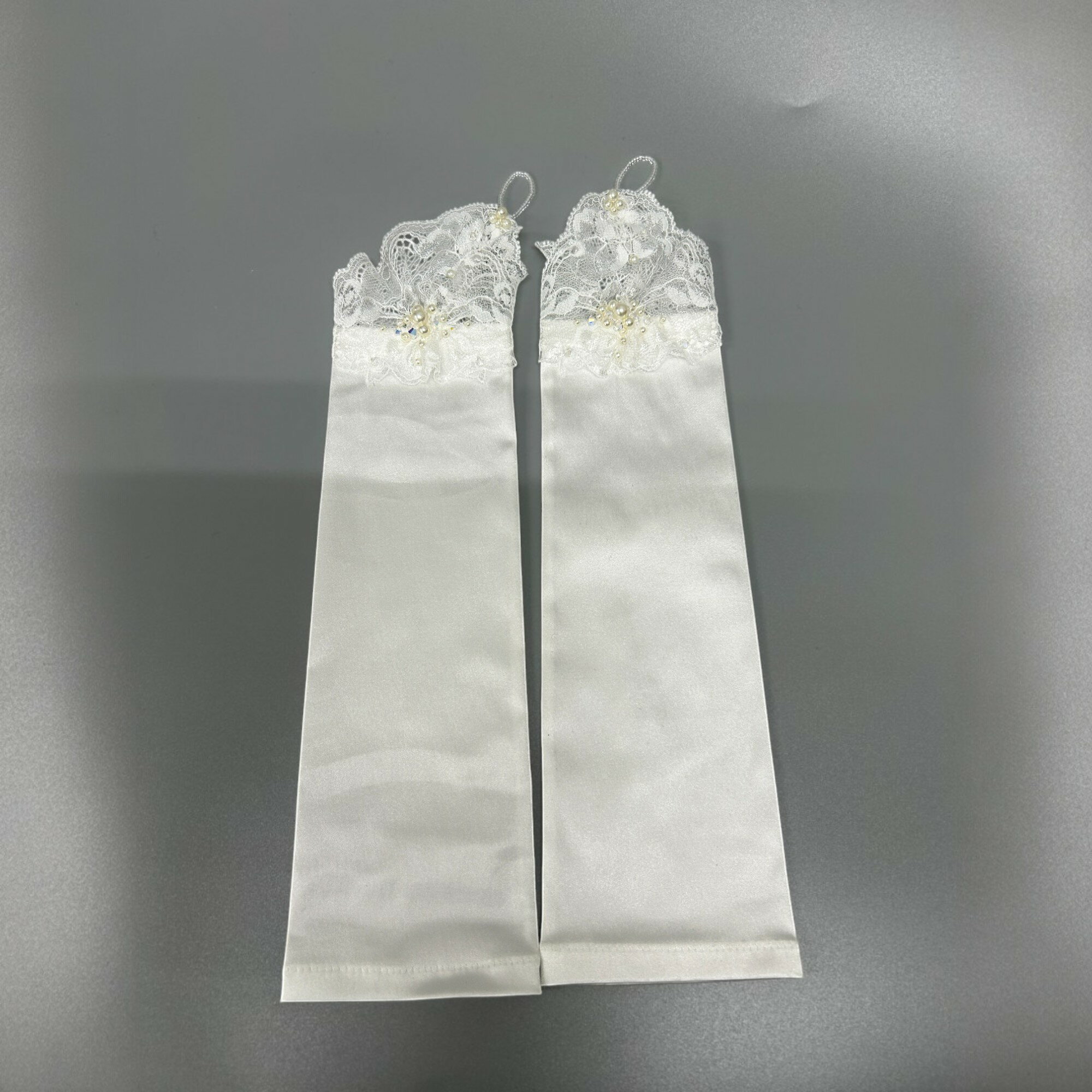 商品情報素材/材質ナイロン　100%その他商品説明このエレガントなロンググローブは、特別なイベントやフォーマルなシーンにぴったりのアクセサリーです。 上質なサテン素材を使用し、手首部分には繊細なレースとビーズの装飾が施されています。カラーは...