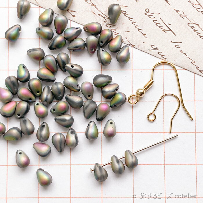 コロンとしたシルエットの可愛らしいドロップビーズ。チェコ製のガラスビーズです。 【サイズ】 4 × 6ミリ (画像のマス目は1センチ四方です) 【個数】 48個 【色味】艶消しクリアにシルバー、グリーン、ピンク系のメタリックコーティング。ブ...