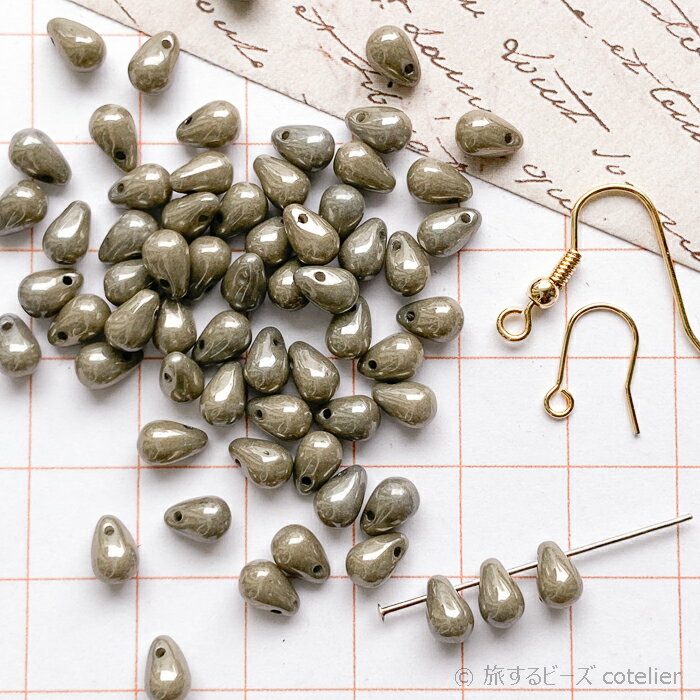 コロンとしたシルエットの可愛らしいドロップビーズ。チェコ製のガラスビーズです。 【サイズ】 4 × 6ミリ (画像のマス目は1センチ四方です) 【個数】 48個 【色味】不透明ホワイトにグレーラスター加工。 【色違い】cotelier-dr...