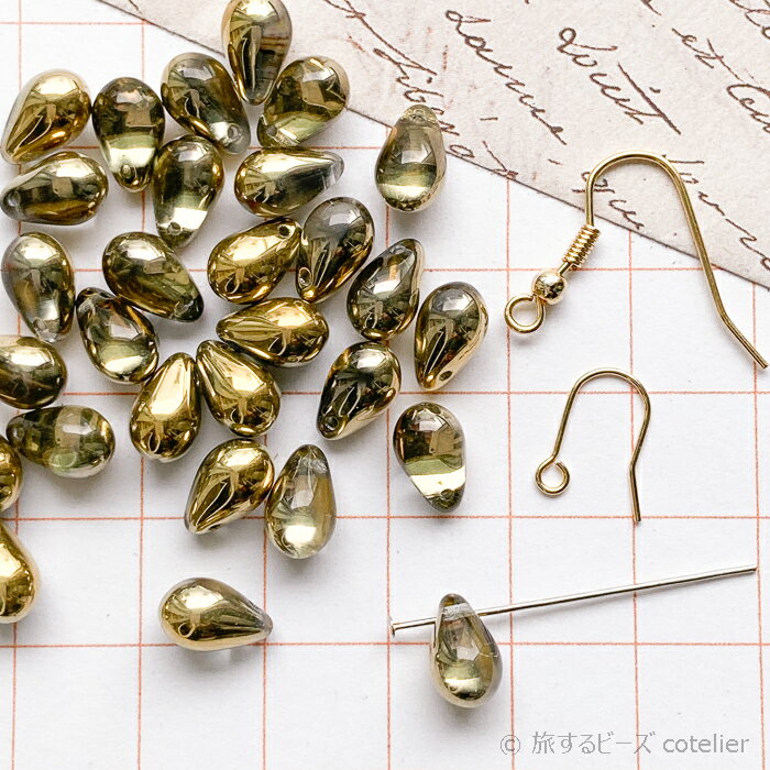 コロンとしたシルエットの可愛らしいドロップビーズ。チェコ製のガラスビーズです。 【サイズ】 6 × 9ミリ (画像のマス目は1センチ四方です) 【個数】 18個 【色味】クリアに明るめのゴールド系の部分的メタリックコーティング。 【色違い】...