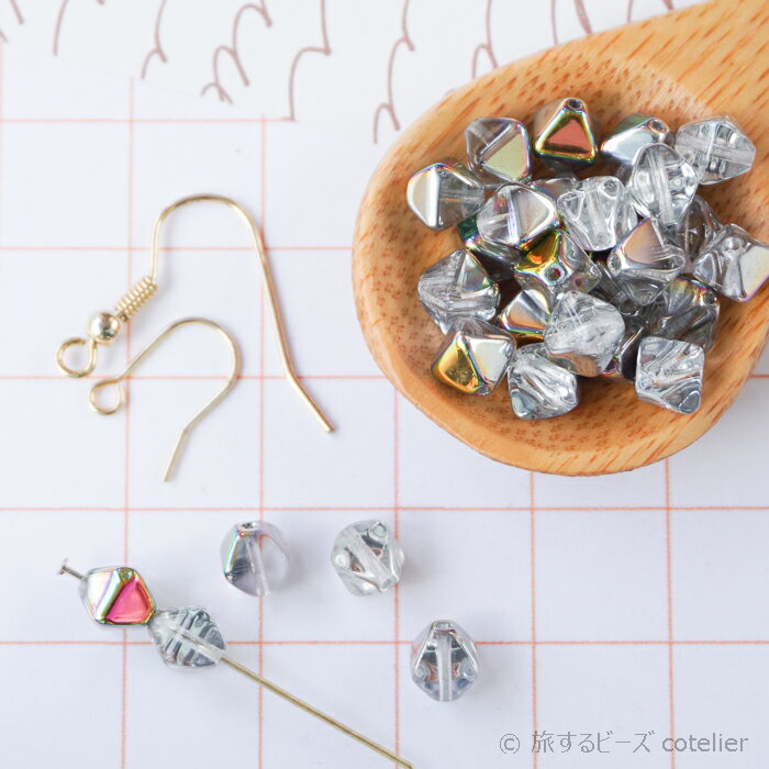 コロンとしたシルエットの8面体ビーズ。チェコ製のガラスビーズです。 【サイズ】 6ミリ (画像のマス目は1センチ四方です) 【個数】 38個 【色味】 クリアに部分的シルバーにピンク～イエローグリーン系コーティング 【色違い】cotelie...