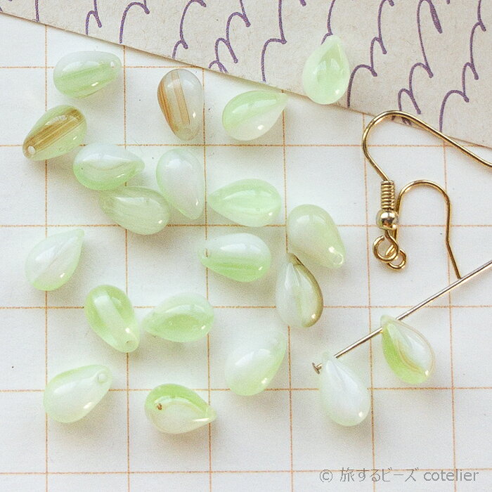 コロンとしたシルエットの可愛らしいドロップビーズ。チェコ製のガラスビーズです。 【サイズ】 6 × 9ミリ (画像のマス目は1センチ四方です) 【個数】 18 個 【色味】不透明ホワイトとクリアペリドットグリーン、僅かにオレンジが混ざってい...