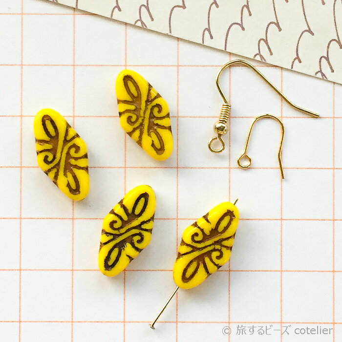 一粒でも存在感のあるアラビア文様のプレスビーズ。チェコ製のガラスビーズです。 【サイズ】 9x19ミリ (画像のマス目は1センチ四方です) 【個数】 4 個 【色味】不透明イエロー。ブロンズ系コーティング。 【色違い】cotelier-ar...