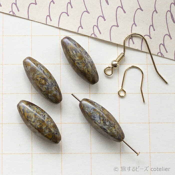 6面のロングオリーブ型プレスビーズ。チェコ製のガラスビーズです。 【サイズ】 7x19ミリ (画像のマス目は1センチ四方です) 【個数】4個 【色味】マットな質感のシルバーブルーにまだら感のあるベージュ系コーティング 【色違い 一覧】cot...