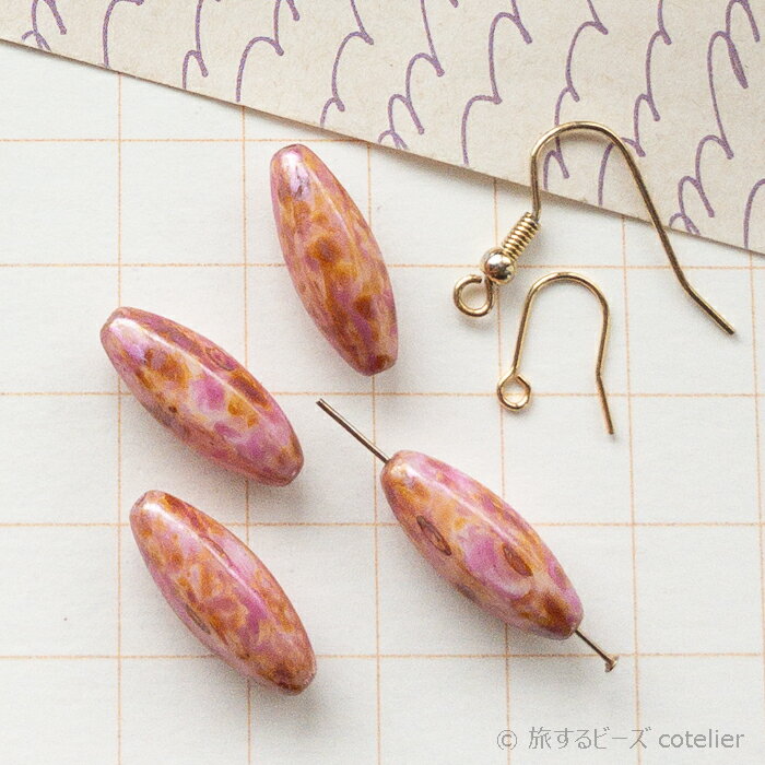 6面のロングオリーブ型プレスビーズ。チェコ製のガラスビーズです。 【サイズ】 7x19ミリ (画像のマス目は1センチ四方です) 【個数】4個 【色味】メタリックライトピンクにまだら感のあるベージュ系ピカソコーティング 【色違い 一覧】cot...