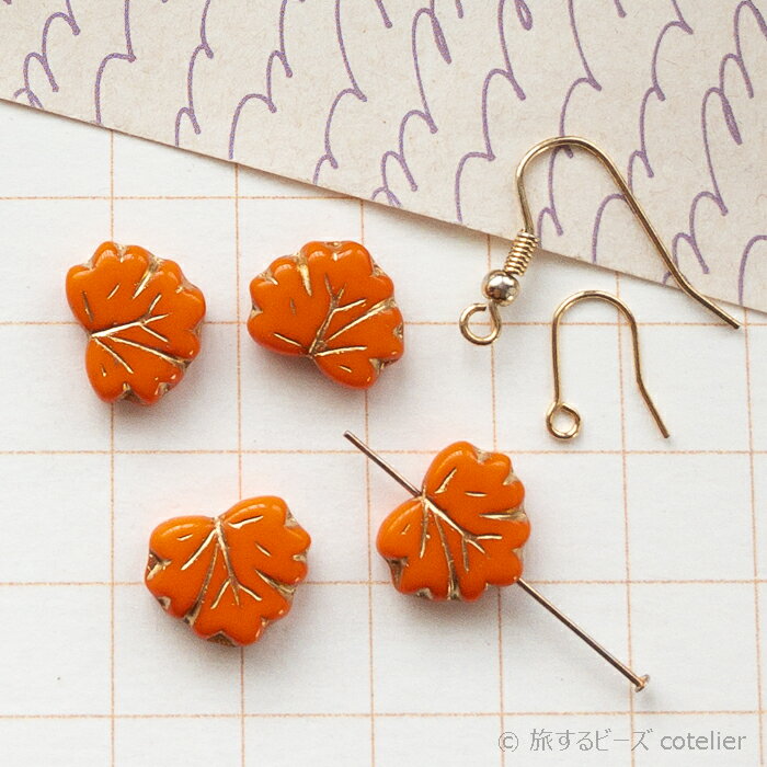 メープルやグレープの葉のようなプレスビーズ。チェコ製のガラスビーズです。 【サイズ】 11x13ミリ (画像のマス目は1センチ四方です) 【個数】 4個 【色味】不透明なオレンジ。ライン部分にゴールド系コーティング 【色違い】cotelie...