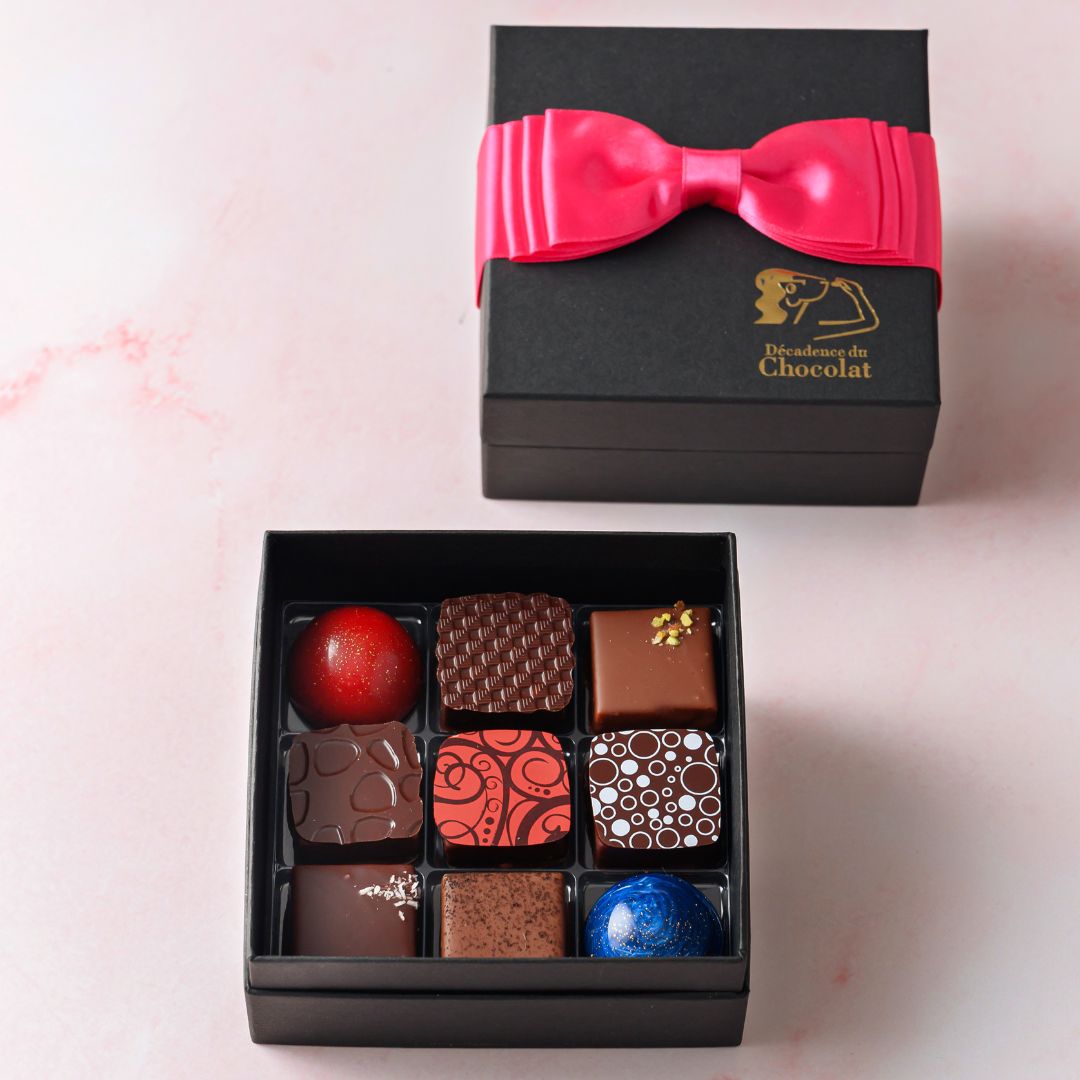 レッド、ブルー・・ 2026はPOPでキュートに ピンクのリボンで想いを結ぶ。 9粒入りのBOXには今年も赤いローズが健在。 ニューフレイバーはまるで地球のような一粒、 バナナ、パッションフルーツ、マンゴーが一度に味わえる トロピカルなブル...