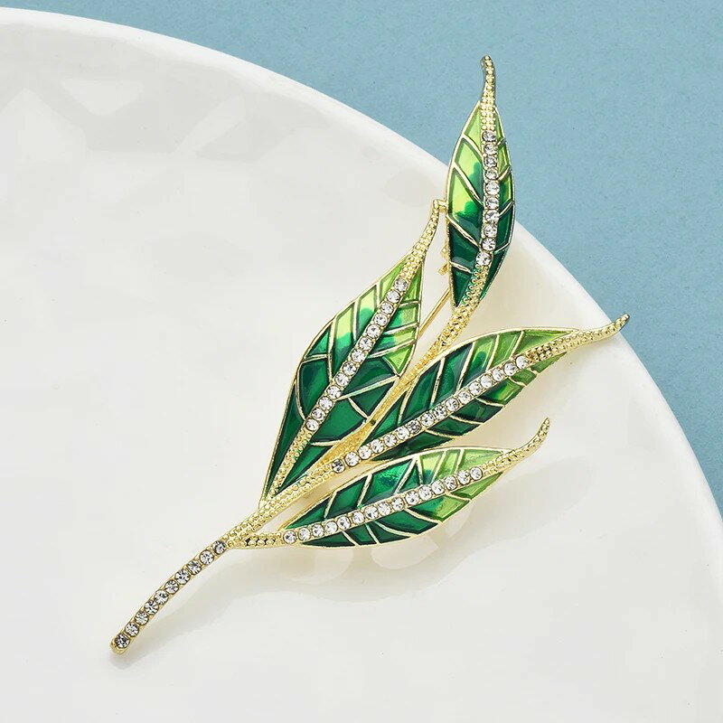 エレガントに輝くリーフブローチ｜7.9cm×3.3cm 大人の上品アクセサリー 深みのあるグリーン×ゴールドの配色が美しい、リーフモチーフのブローチです。 ラインストーンが繊細に輝き、コーデに華やかさをプラス。 ジャケット・ワンピース・スト...