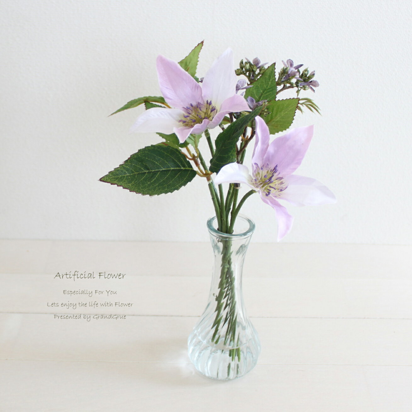 こちらの作品は受注生産になります。納期は1週間程度となります。クレマチスのマジカルウォーターアレンジメント本物のお水に見えるのはマジカルウォーター（人工水）。樹脂で出来ていて、固まっているの傾けてもでこぼれません。 グリーンインテリアとして...