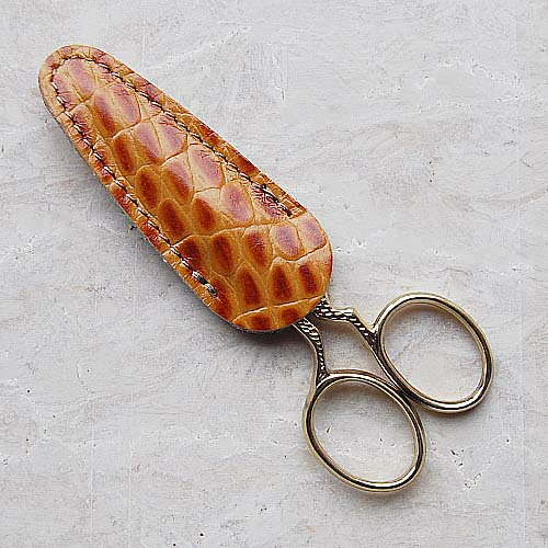 牛革製ハサミカバー。大切なハサミを守ります。 10センチくらいまでのハサミにお使いいただけます。 柔らかい羊革です。 色はカーキで、トカゲ革の型押しの模様がついています。 丈夫な素材ですので、安全にハサミを片付けることができます。 サイズ：...