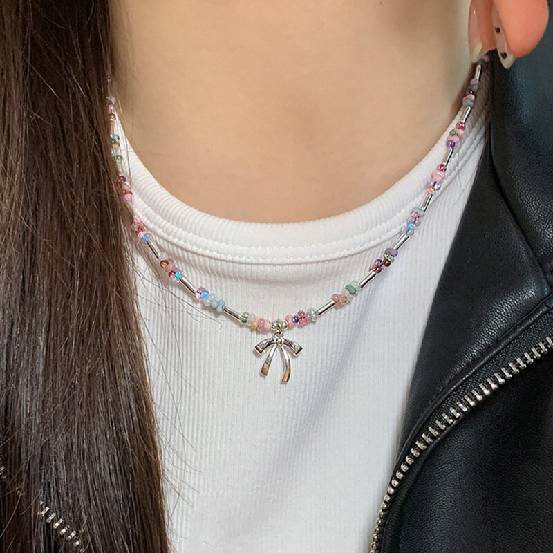 このリボンデザインの金属風ネックレスは、韓国ファッションのトレンドを取り入れたスタイリッシュなアイテムです。カラフルなビーズと金属パーツが絶妙に組み合わさり、どんなコーディネートにもぴったり。特別な日やカジュアルな日常使いにも最適です。