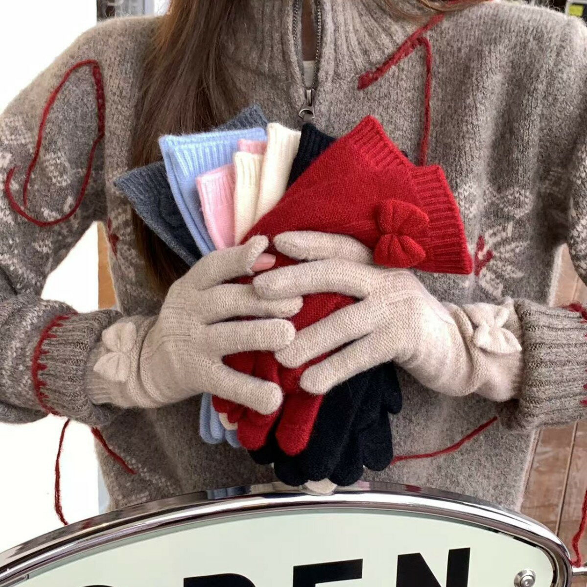 このニット手袋は、かわいいリボンデザインが特徴のレディースアイテムです。韓国ファッションを取り入れたスタイリッシュなデザインで、7色のバリエーションからお選びいただけます。寒い季節にぴったりの温かさとおしゃれを両立させた一品です。