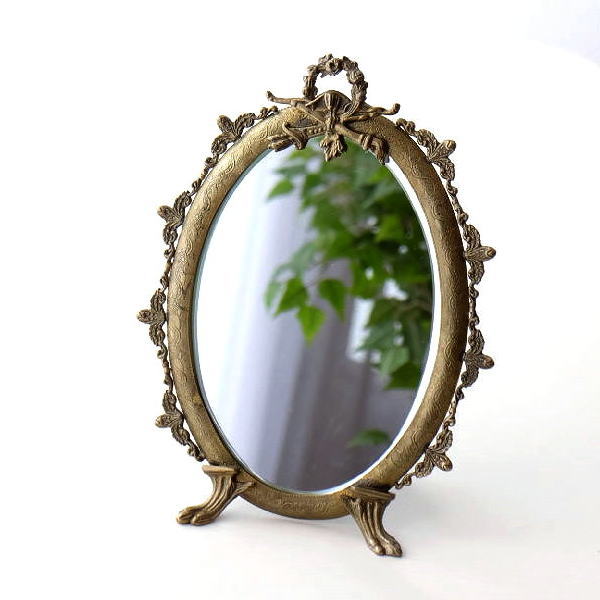 エレガントミラー 鈍い輝きが魅力の真鍮 レトロな風合いは そこにあるだけで おしゃれ空間になりそう。 ロココ調の立体的な装飾で 個性が光るスタンドミラーは レースのような縁飾りやレリーフなど ディティールにこだわったデザイン 重厚感溢れるミ...