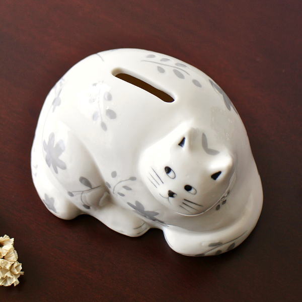 貯金箱 まるく身体を丸めて ちょこんとこちらを見上げる猫の姿が可愛い 見ているだけで心がほどけるような 愛らしい猫の貯金箱 つるんとした磁器に花模様をあしらった ナチュラルで落ち着いた雰囲気は インテリアとして飾っても絵になり お部屋に優し...