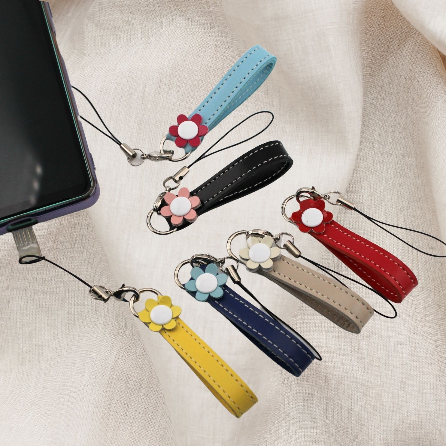 素材：牛革 革ストラップ部サイズ： 長さ 約6cm、幅 約1cm ・手に馴染むレザーに、愛らしいお花モチーフをあしらったストラップです。 ・スマホや鍵、パスケースなどに取り付ければ、毎日の持ち物がぐっと華やかに。 ・レザー部分は丈夫で長く愛...