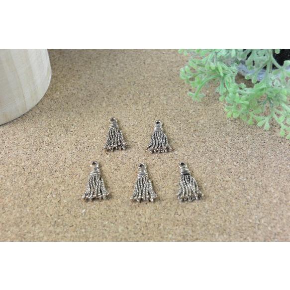 タッセル型モチーフパーツ金具5PCS入りです。アクセサリーのハンドメイド素材として、ファッションアイテムのアクセントとしてご利用ください。SIZE：約　横20mm×12mm（穴含む）個 数:5個入りメッキ:アンティークブロンズ品 番:AP0...