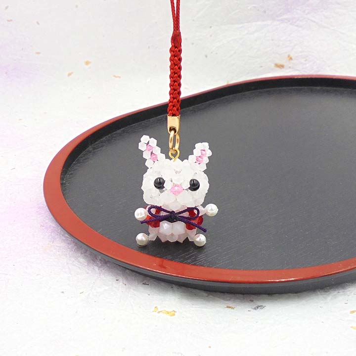 アクリルビーズで作る、赤いちゃんちゃんこを着たうさぎの根付けです。 後ろ側にはちゃんとしっぽもついていますよ。 コロンとした形が可愛らしいうさぎです。 《出来上がりサイズ》約3×4cm、全長約11.5cm（根付け含む） 《用意する物》ハサミ...