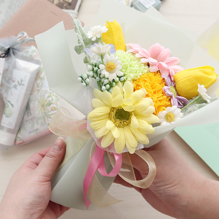 優しい気持ちを込める、爽やかなブーケラッピングの方法につきまして仕様・規格部分をお読みください。 贈りものの定番、一番喜ばれる「花」。心やすらぐハンドクリームとリバティの花柄ハンカチをセットにした贈りものをご用意しました。 造花と石鹸の素材...