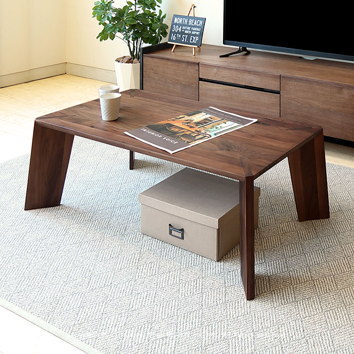 重厚感のあるローテーブル ウォールナット ウォールナット無垢材を継ぎ合わせた重厚なデザインのリビングテーブル（幅100cm）。 斜めにカットされた脚や天板の縁、接合部などの細部のしつらえが存在感を際立たてます。 脚が天板を貫通したようなデザ...