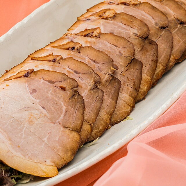 創業当初から守り続ける秘伝のたれを使いじっくりと炊き上げた焼き豚です。 時間をかけて炊き上げた豚もも肉のブロックを数日かけて寝かし、味をしみこませていきます。窯から出して手切りでカット。 しっとりと秘伝たれがしみ込んだ焼き豚の美味しさは格別...