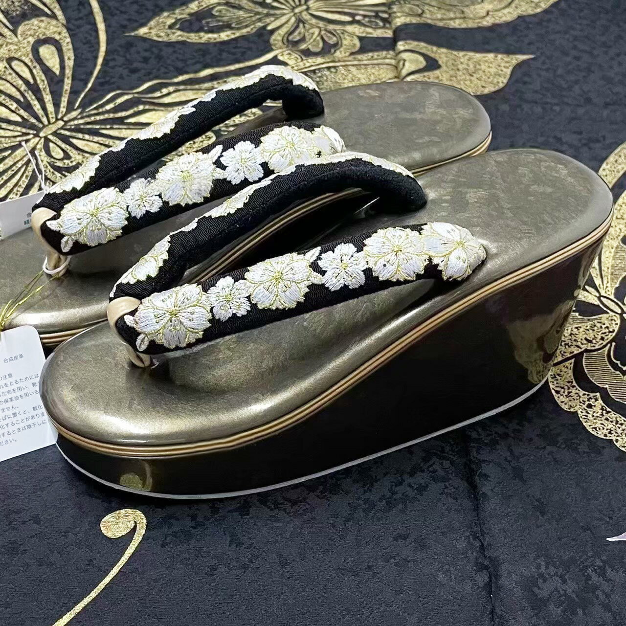 商品情報素材/材質台 鼻緒合成皮革サイズ/寸法適応サイズ 23.0～24.5cm 草履全長 約24.5cm かかとの高さ ゴム含め約9.0cm前　　　約2.5cm幅　　　約7.5cmその他商品説明鼻緒には金ラメ糸を使用した贅沢な桜の刺繍をあ...