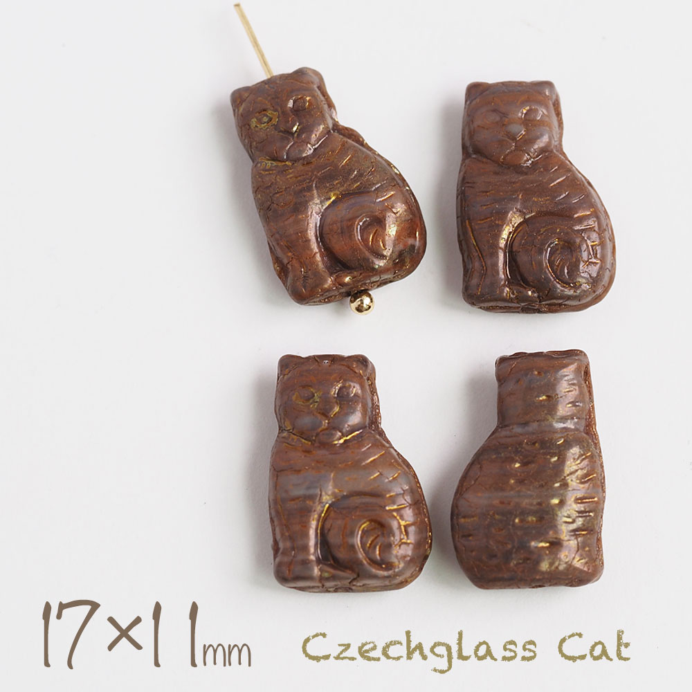 後ろ姿もカワイイお座り猫モチーフのチェコビーズです。両面に彫模様と着色が施されています。ピアスやネックレス等アクセサリーや小物作りにおすすめです。 サイズ：約17×11mm、厚さ：約5mm 販売単位：4個 生産国：チェコ共和国 ご返品につい...