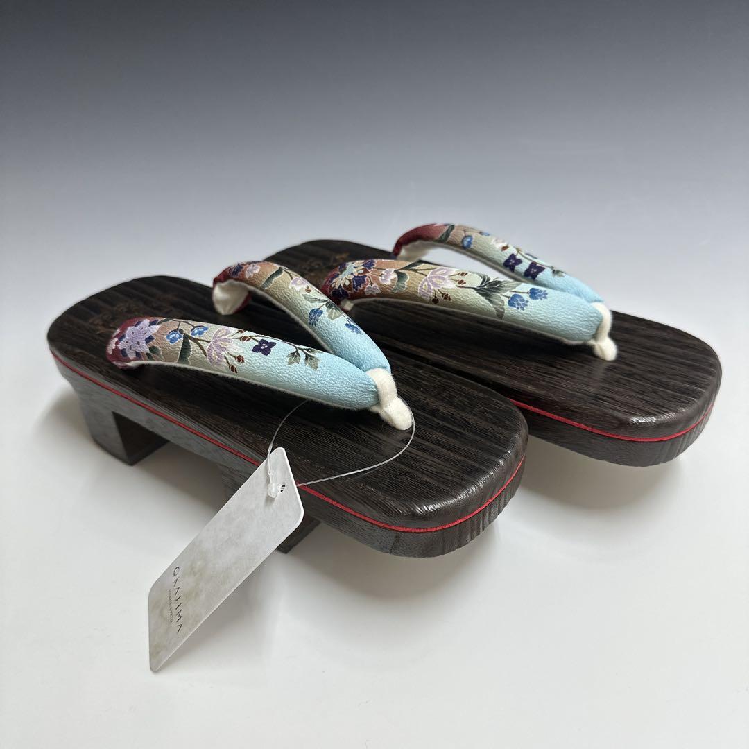 商品情報素材/材質台　桐鼻緒　ポリエステルサイズ/寸法フリーサイズ全長　約24.5cm幅　　約8.5cm高さ　約6.0cmその他商品説明京都の伝統的な老舗染匠【岡重】謹製の鼻緒を使用した、桐下駄になります。踵に彫り込まれたワンポイントの像柄...